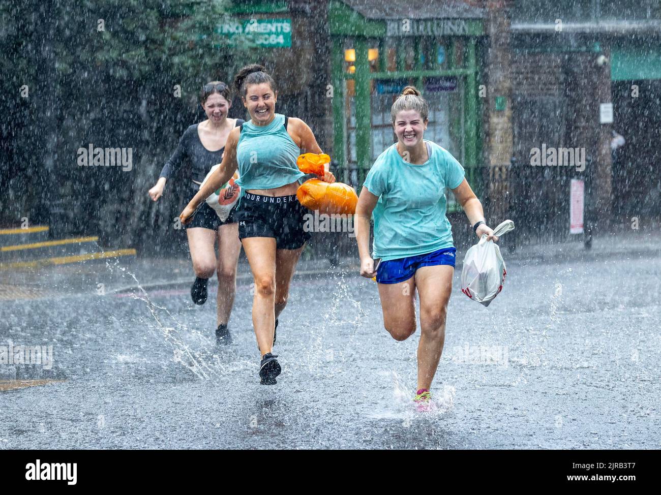 Pic shows: Three young women sprint for cover after getting caught but ...