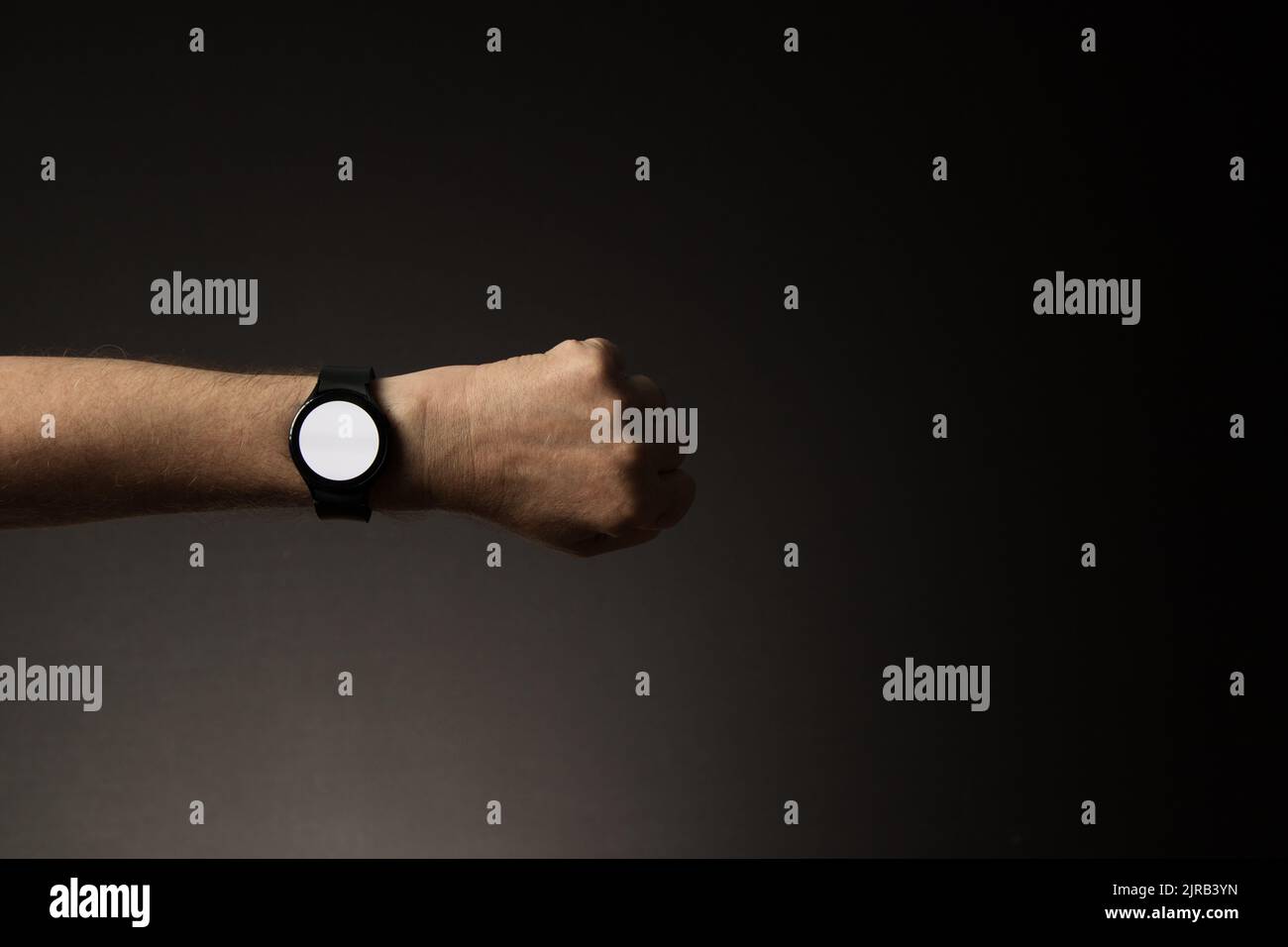 Man's hand with smart watch on wrist, displaying blank white screen ...