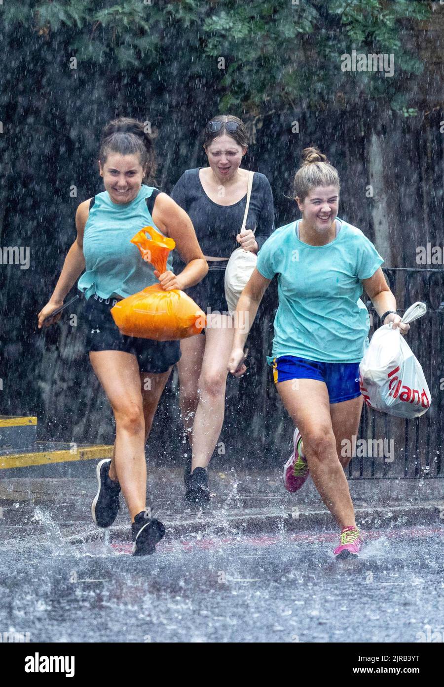 Pic shows: Three young women sprint for cover after getting caught but ...
