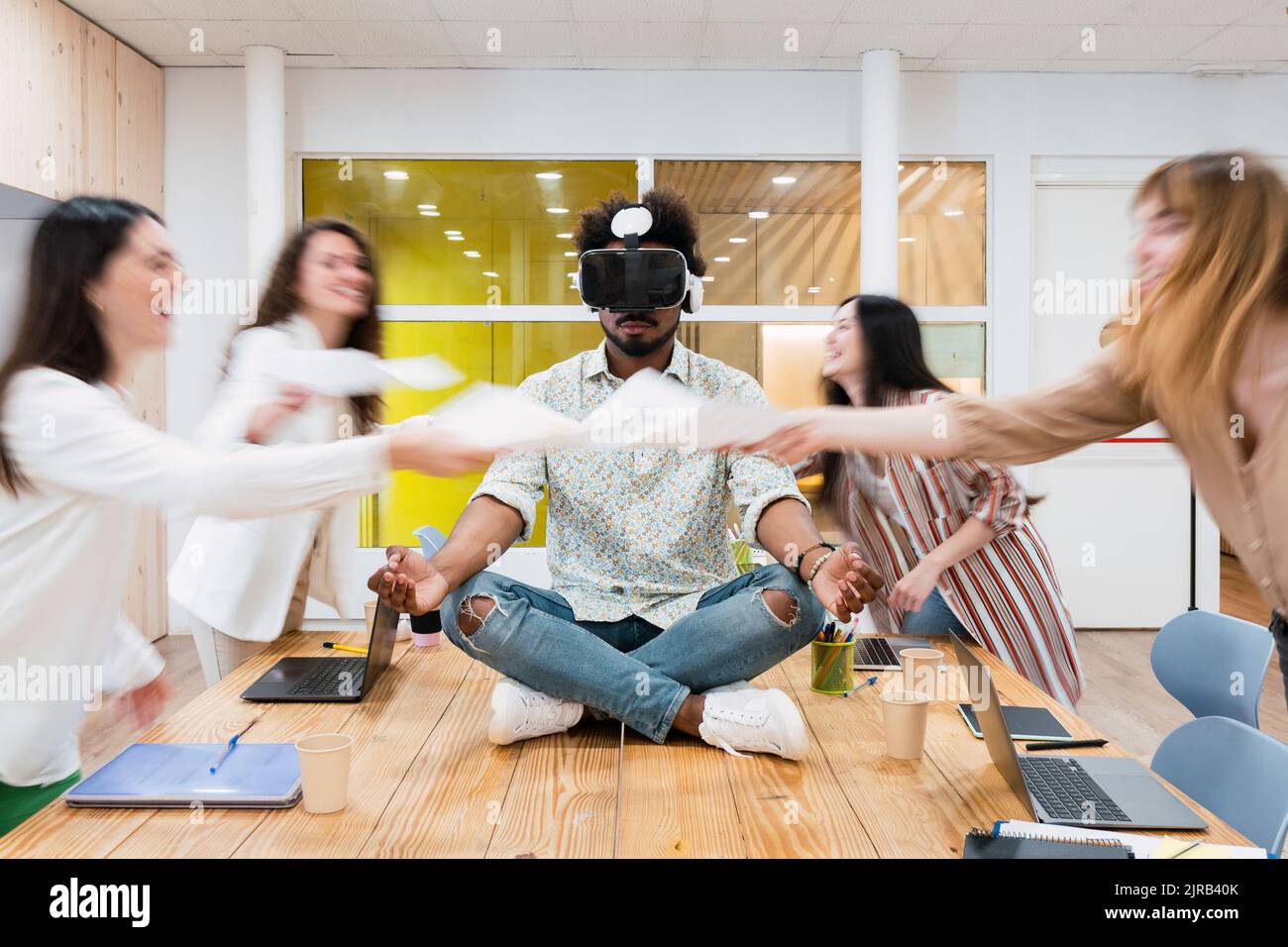 Businessman sitting on desk in conference room in office wearing VR ...