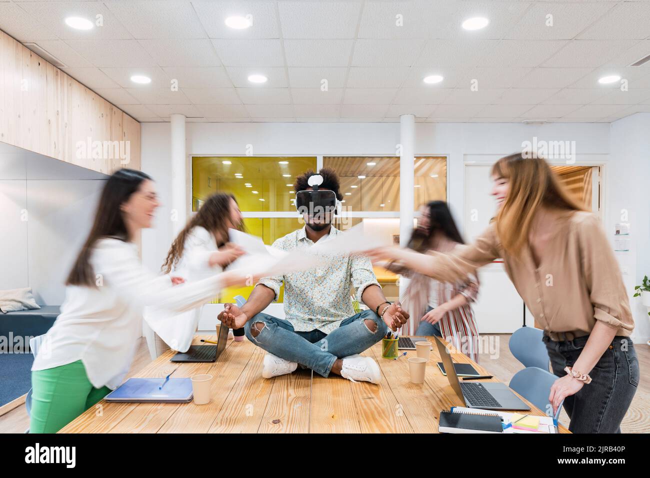 Businessman sitting on desk in conference room in office wearing VR ...