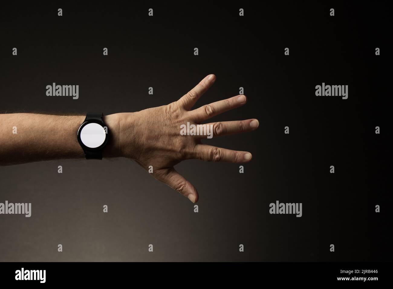 Man's hand with smart watch on wrist, displaying blank white screen ...