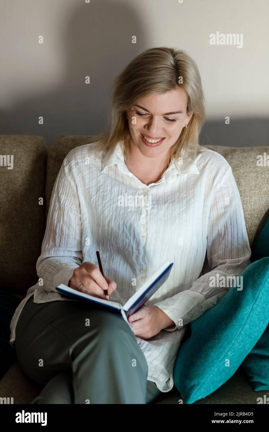 Mature woman writing in diary hi-res stock photography and images - Alamy