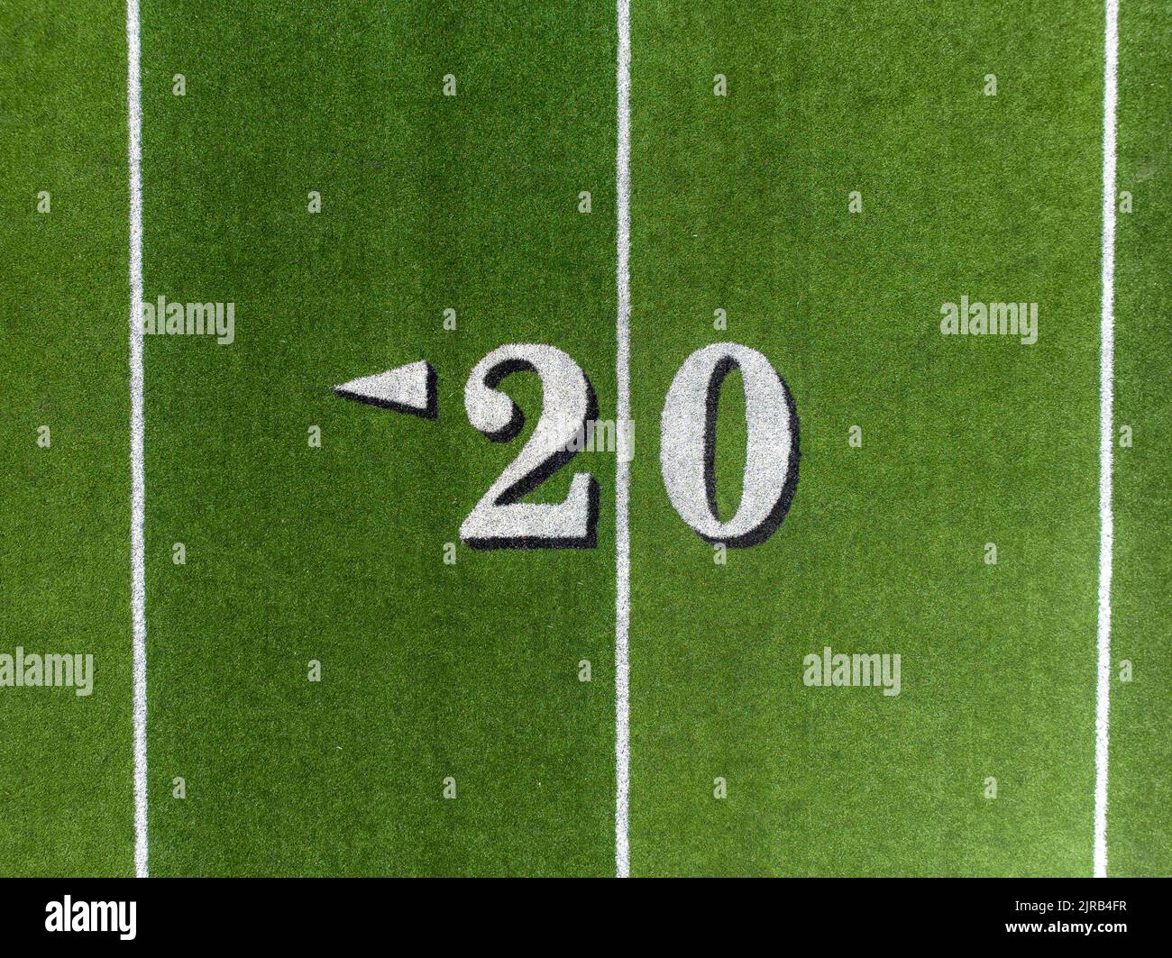 Synthetic turf football fiedl 20 yard line in white numbers and black ...