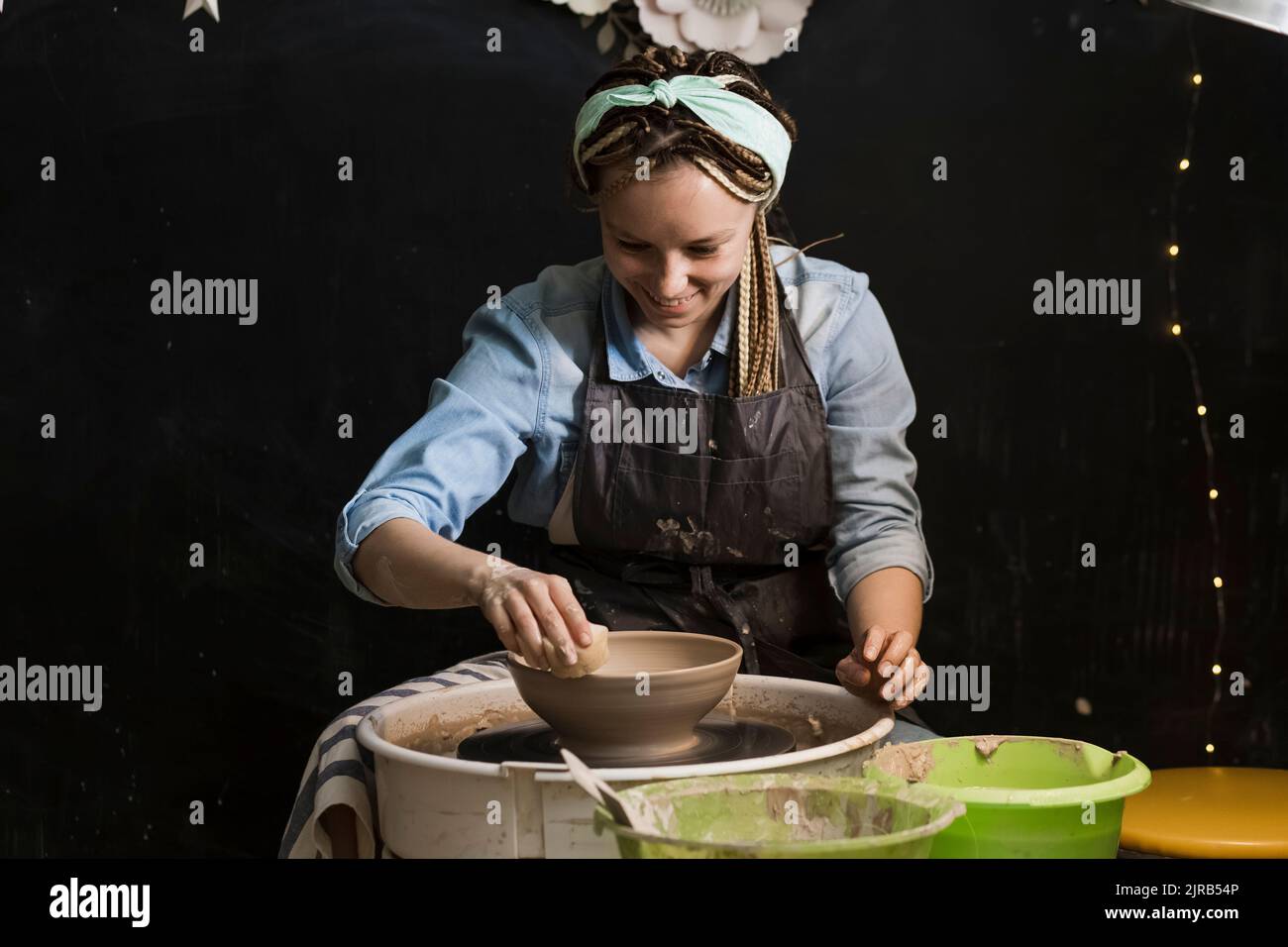 Smiling potter moulding shape on pottery wheel at art studio Stock ...