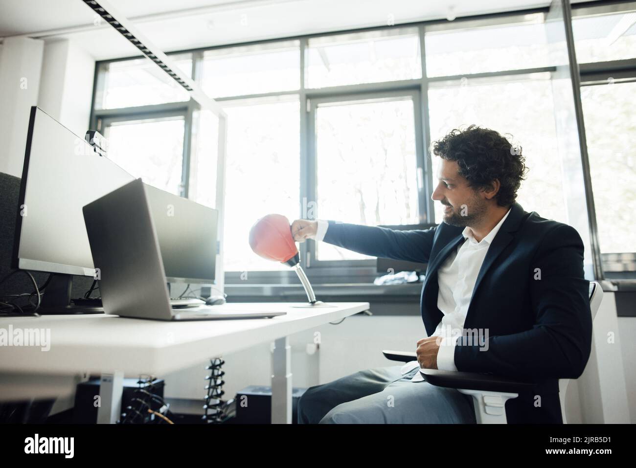 Businessman punching speed bag on desk at workplace Stock Photo - Alamy