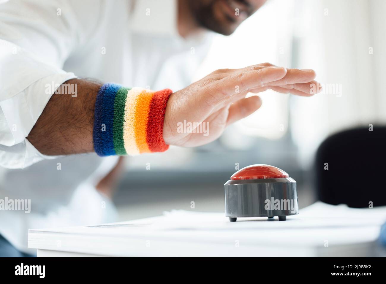 Businessman with hand poised on game show buzzer at office Stock Photo ...