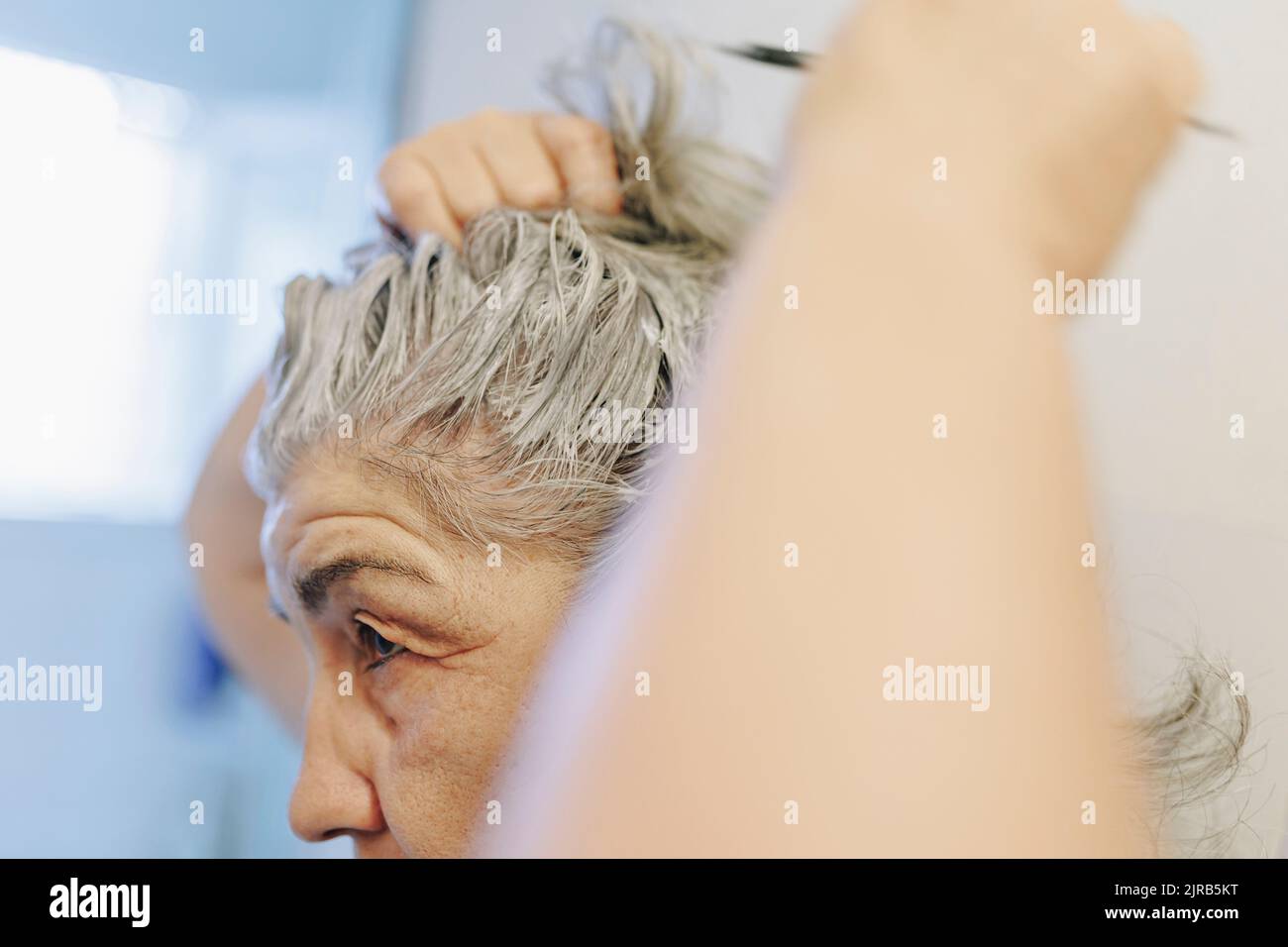 Senior woman applying hair dye at home Stock Photo - Alamy