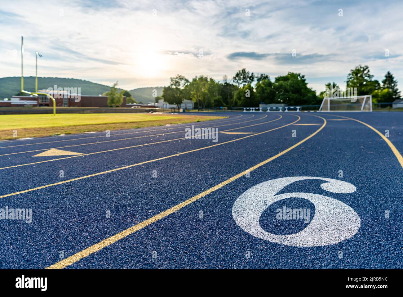 Inspiring close up of a new blue running track with yellow lane lines ...