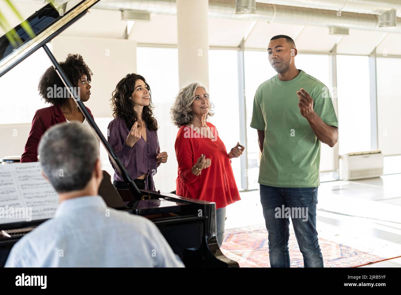 Businessman singing by colleagues snapping fingers in office Stock ...