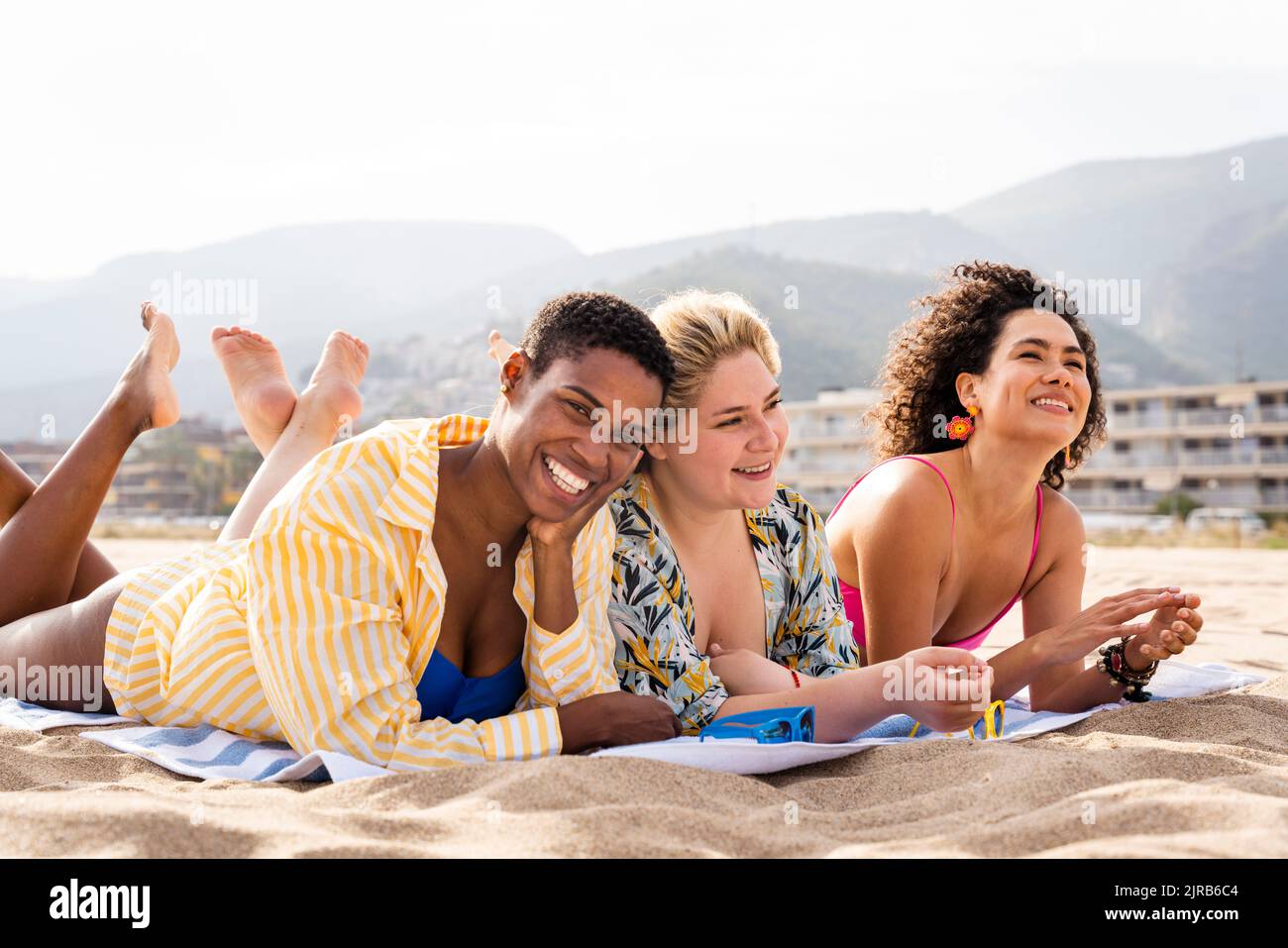 Happy multiracial friends lying down at beach on vacation Stock Photo - Alamy