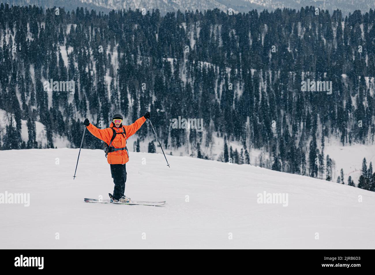 Man with arms outstretched holding ski pole on snow Stock Photo - Alamy