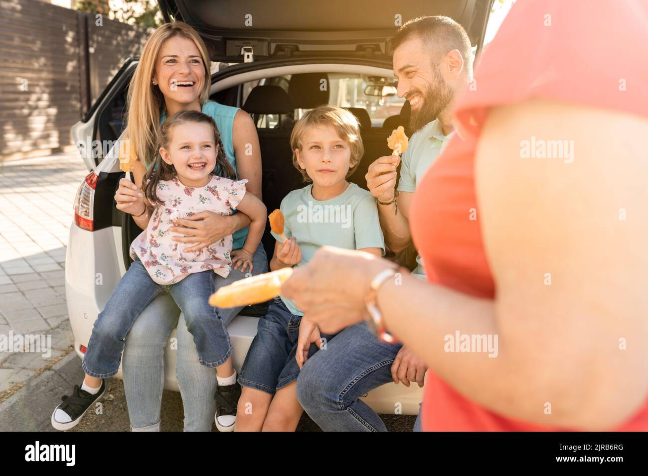 Happy family with ice pops sitting at back of car Stock Photo - Alamy