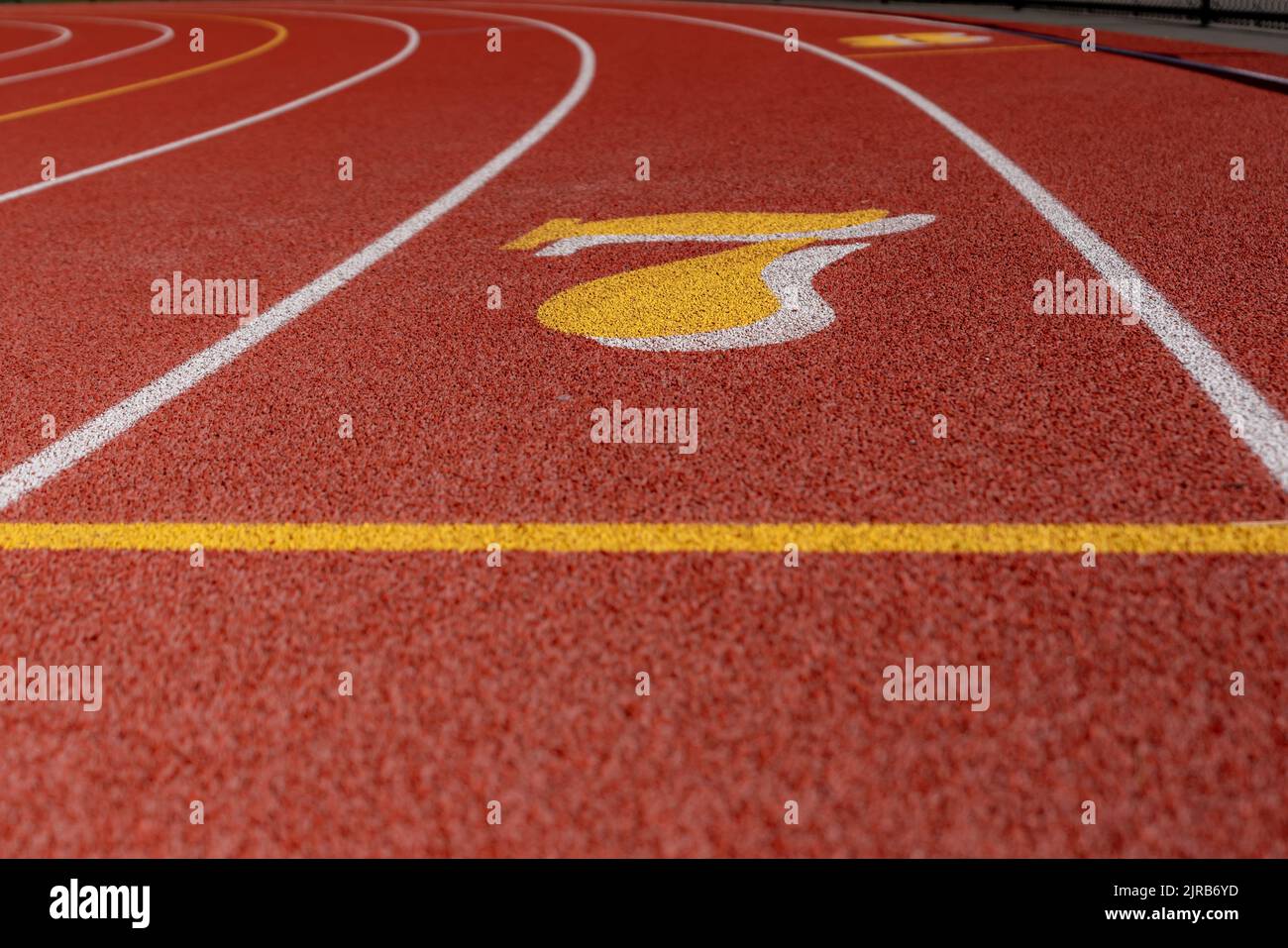 Close up lane number 7 on a new red running track with white lane lines ...