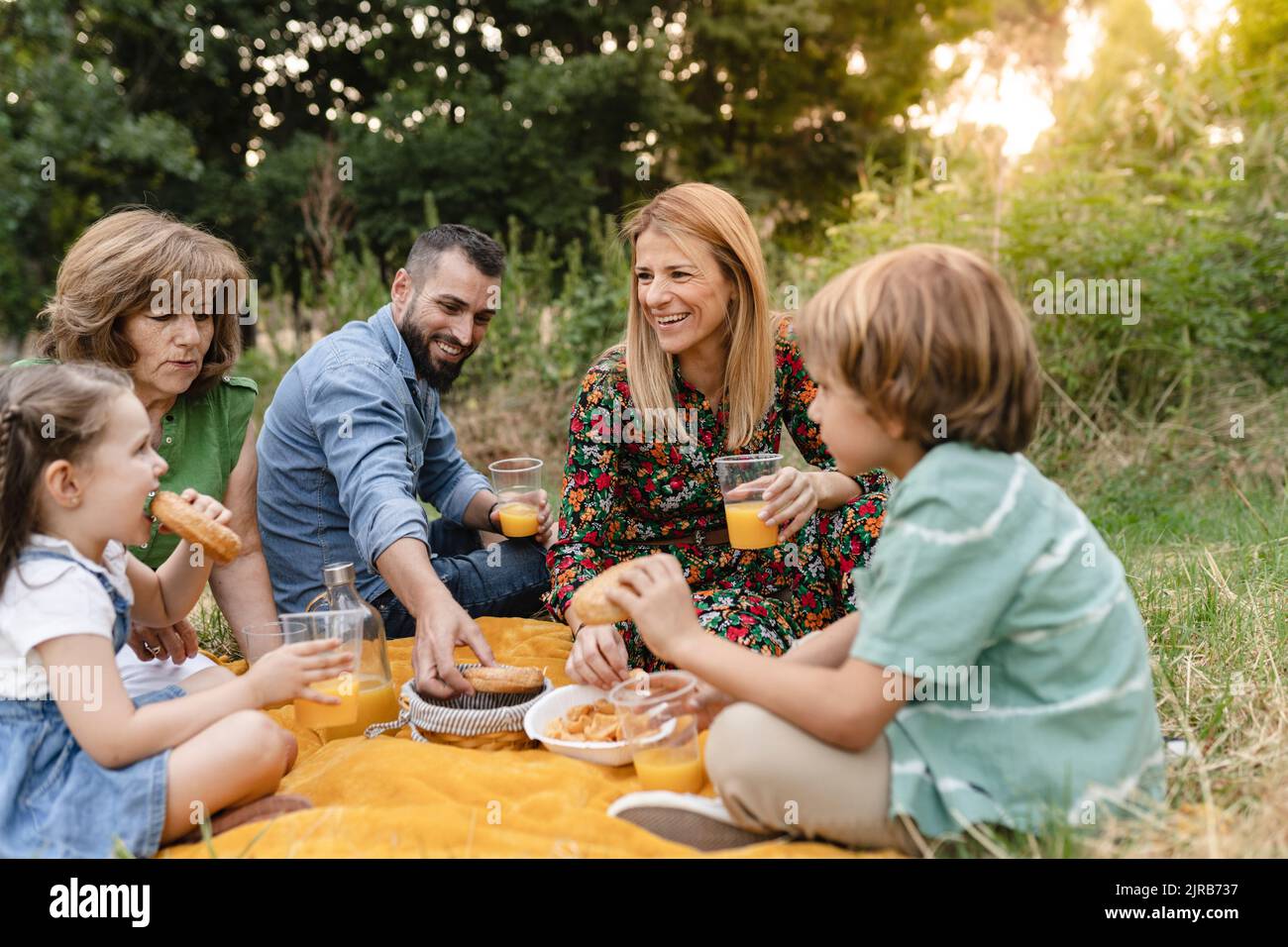 Happy family eating together during picnic in park Stock Photo - Alamy