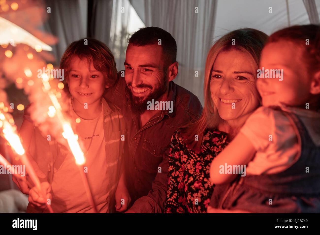 Happy family burning sparklers in the dark Stock Photo - Alamy