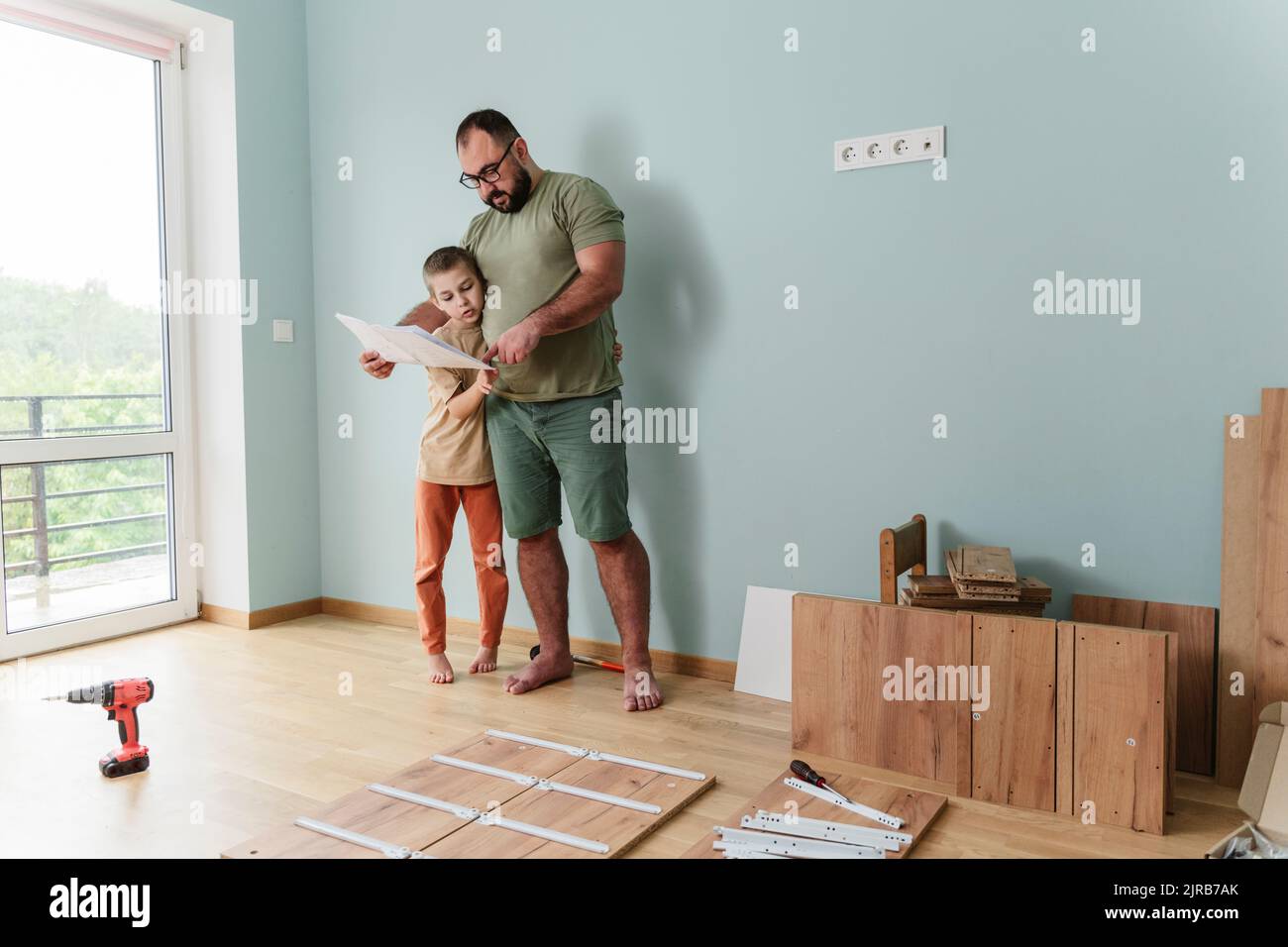Father and son reading manual at home Stock Photo - Alamy