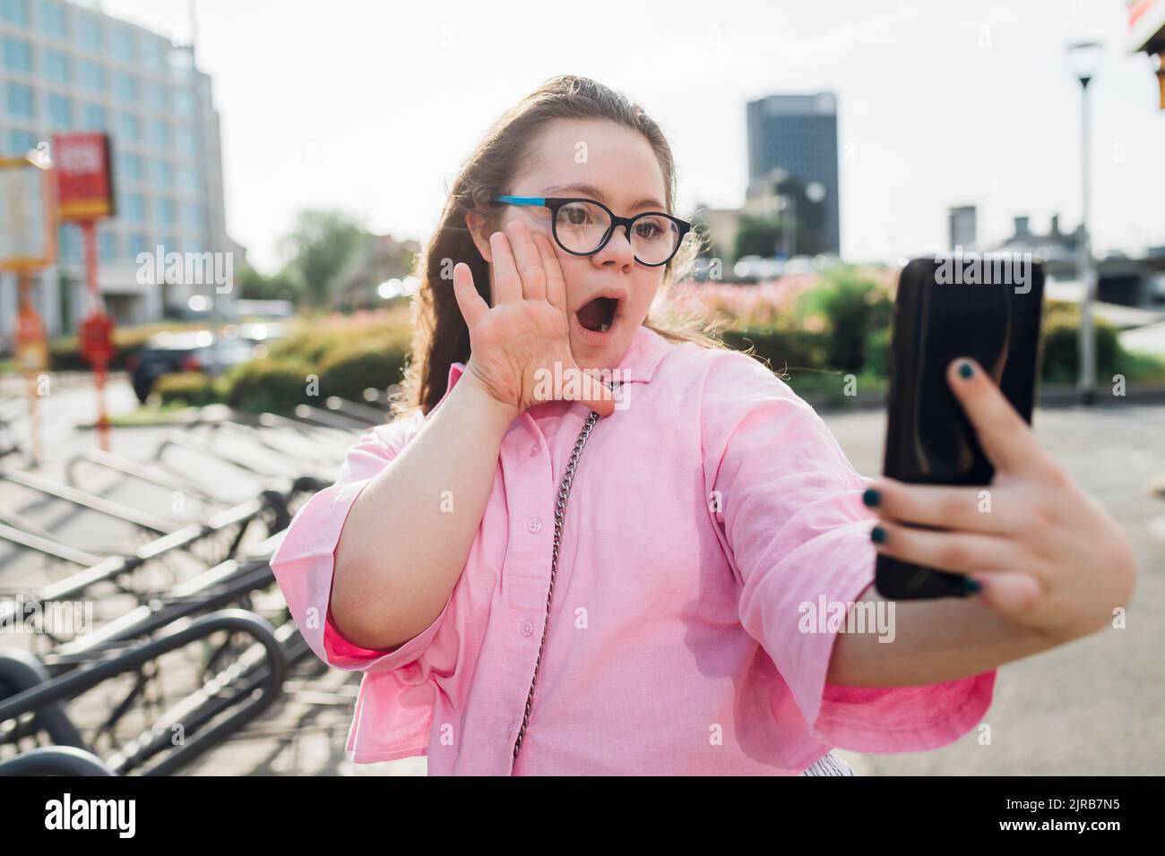 Teenage girl with down syndrome screaming and taking selfie on mobile ...