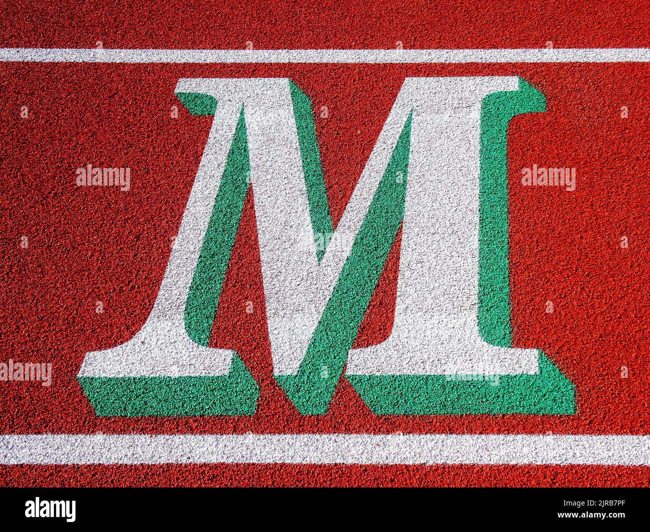 Two tone white and green letter, initial M painted on running track ...