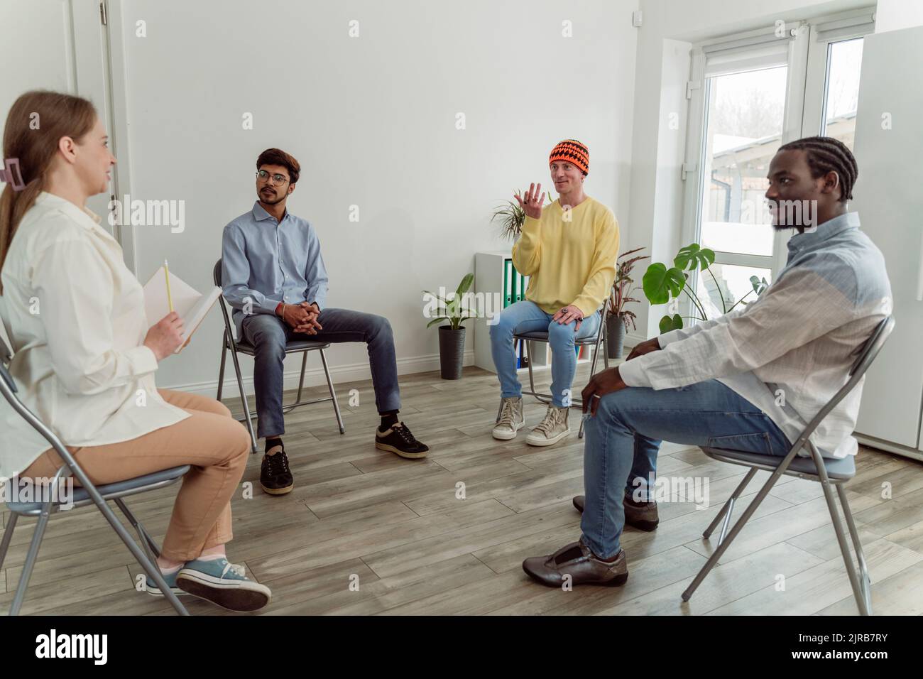Psychologist discussing with patients sitting on chairs Stock Photo - Alamy