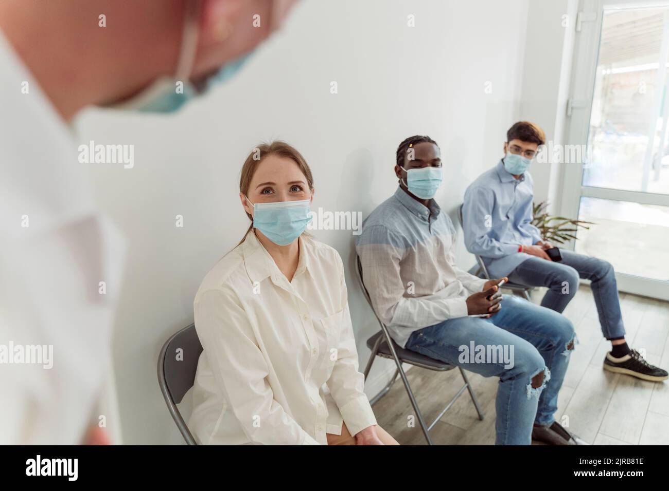 Patients wearing face masks waiting at clinic Stock Photo - Alamy