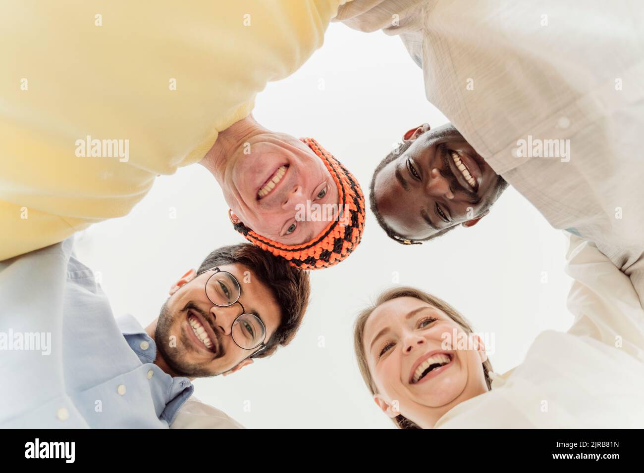 Cheerful colleagues huddling together in team building training Stock ...