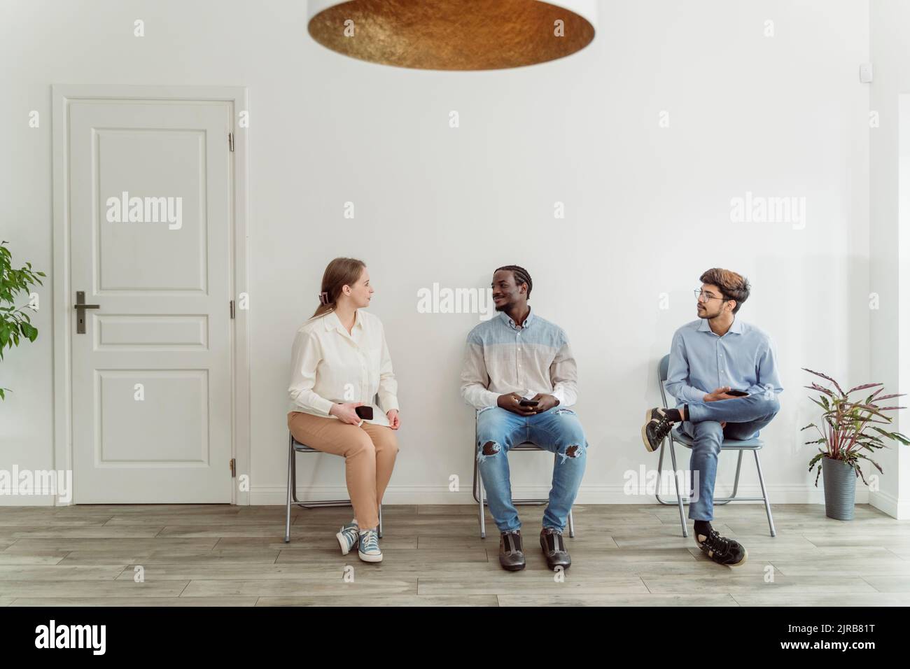 People waiting and talking in waiting area Stock Photo - Alamy
