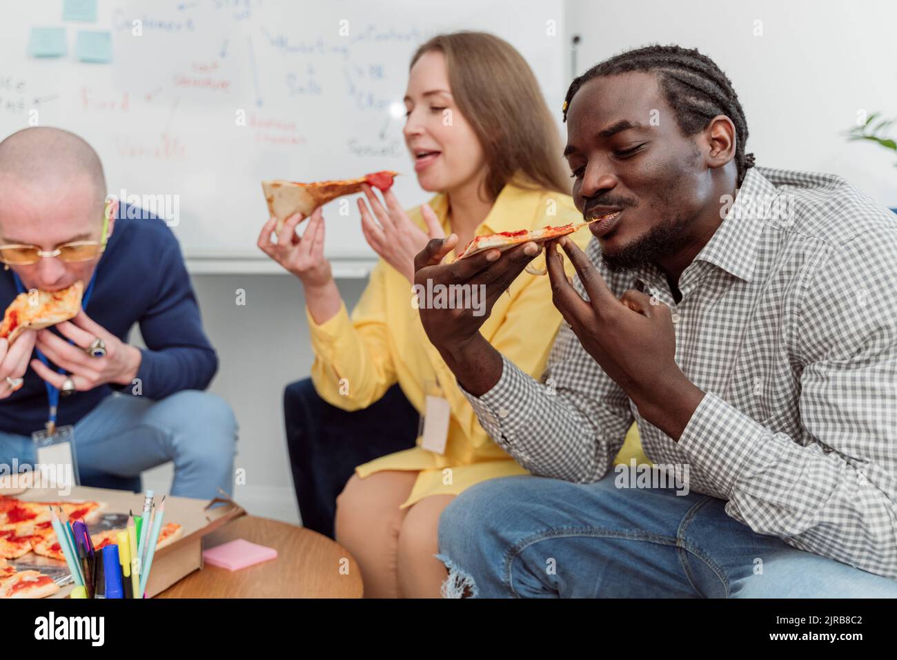 Business colleagues eating pizza in office Stock Photo - Alamy