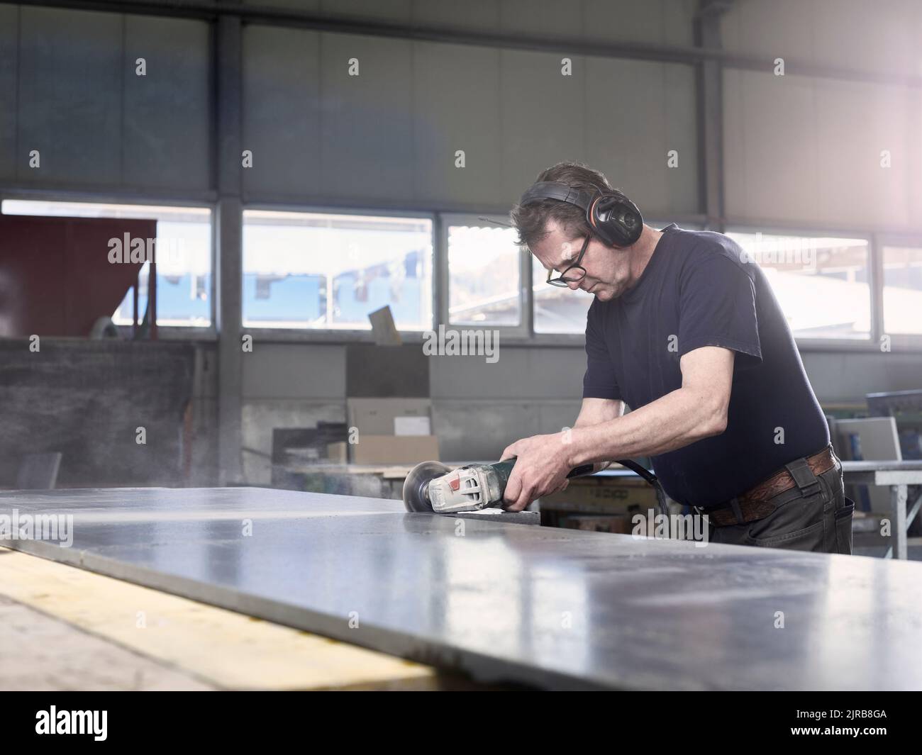 Stonemason cutting marble slab with grinder at workshop Stock Photo - Alamy