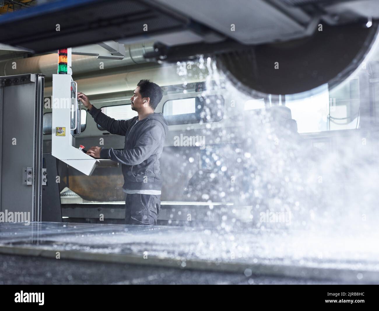 Stonemason operating electric saw through CNC machine at workshop Stock ...