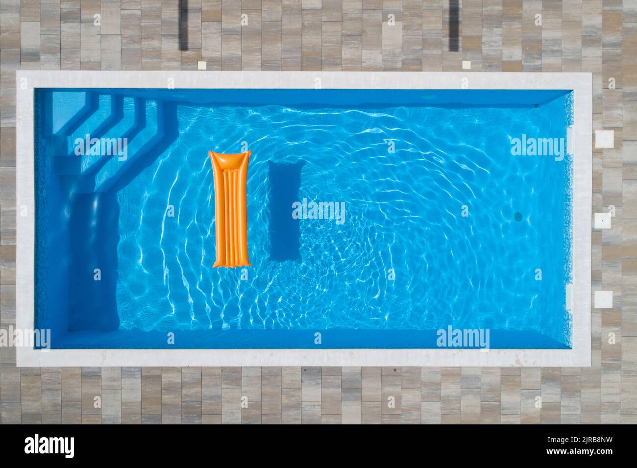 Pool raft floating in swimming pool on sunny day Stock Photo - Alamy