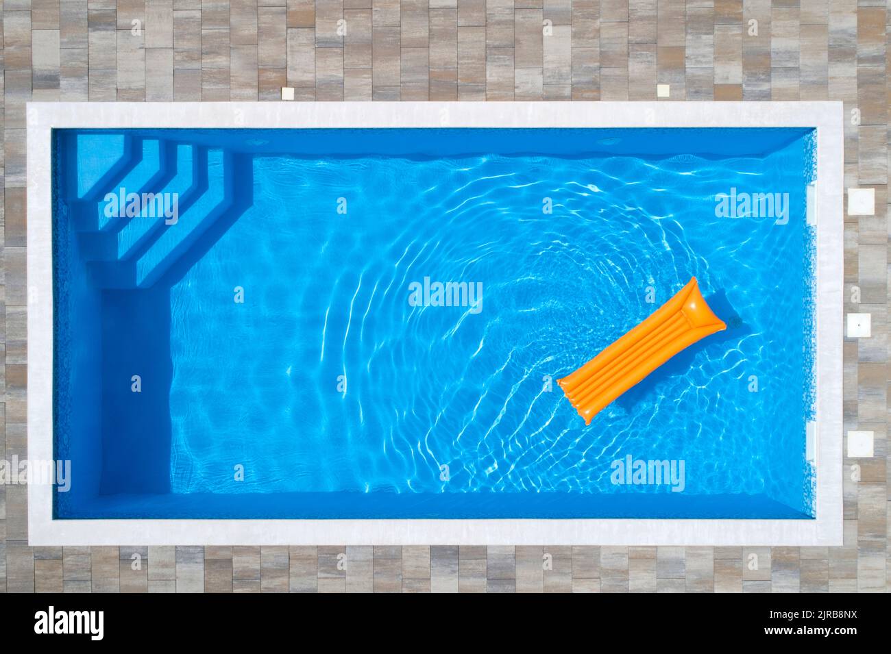 Yellow pool raft floating on water in swimming pool Stock Photo - Alamy