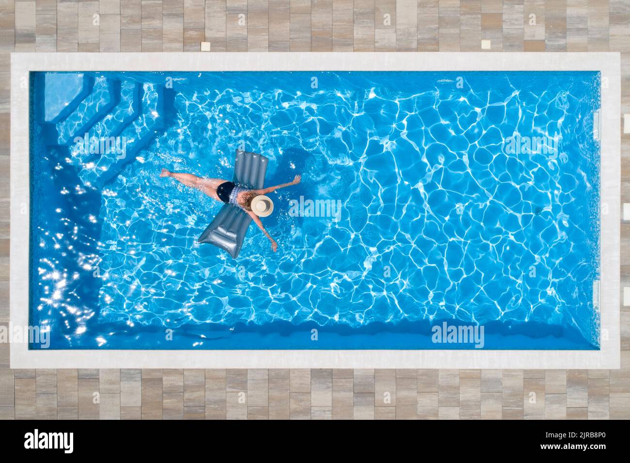 Woman swimming with pool raft in pool Stock Photo - Alamy