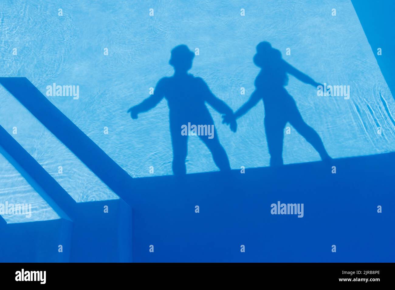 Shadow of couple holding hands seen on water of swimming pool Stock ...