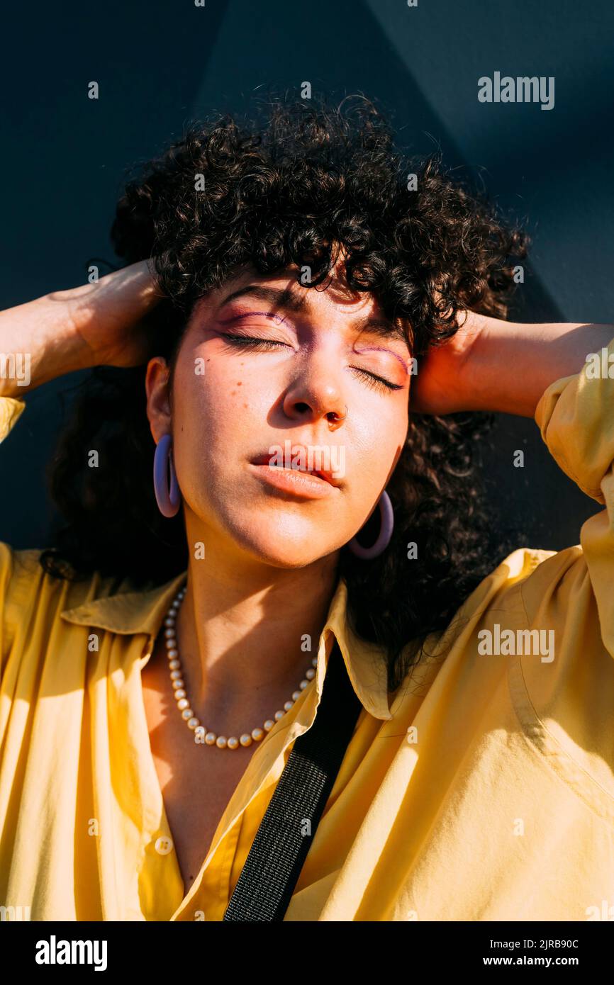 Woman with hands in hair enjoying sunlight Stock Photo - Alamy