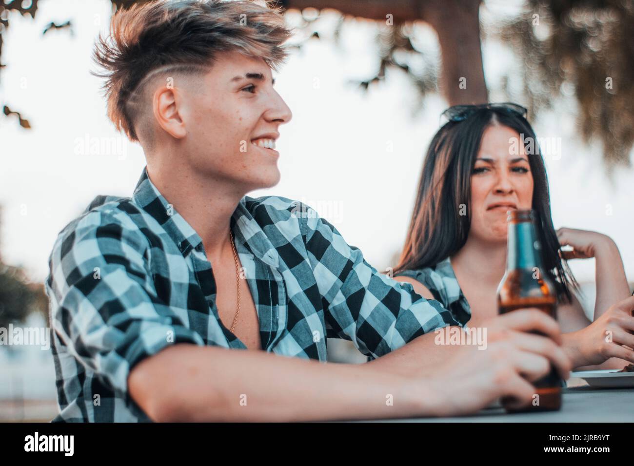 A shallow focus shot of a cute with a guy holding the bottle and a girl ...