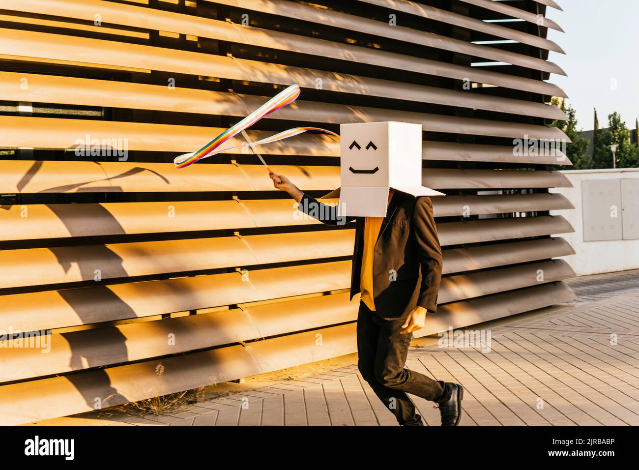 Man wearing smiley face box spinning rainbow colored rhythmic ...