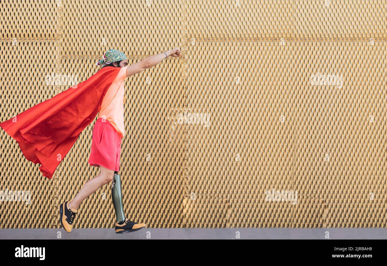 Man with prosthetic leg wearing cape walking in front of wall Stock ...