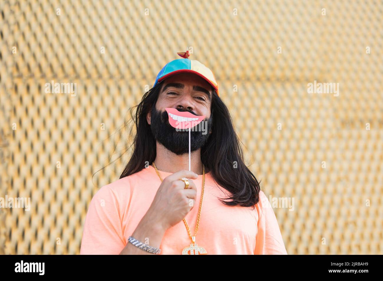 Man wearing cap covering mouth with lip prop in front of wall Stock ...