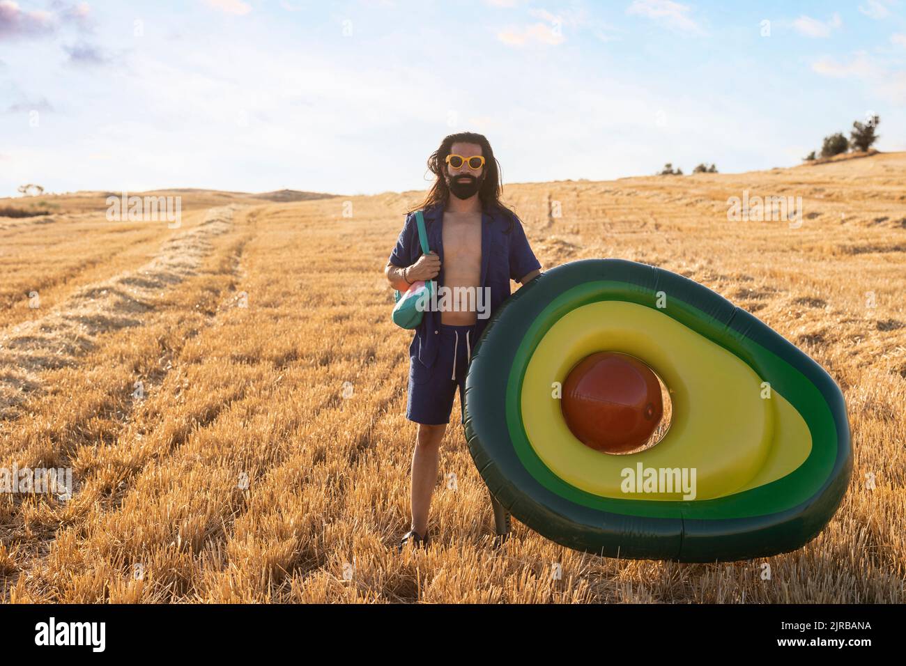 Bearded man with prosthetic leg wearing sunglasses standing by avocado ...