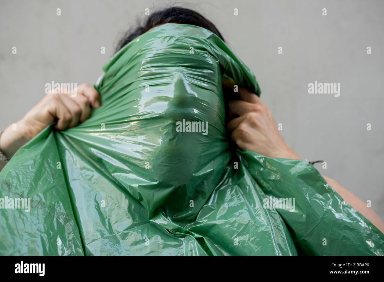 Man covering face with green plastic Stock Photo - Alamy