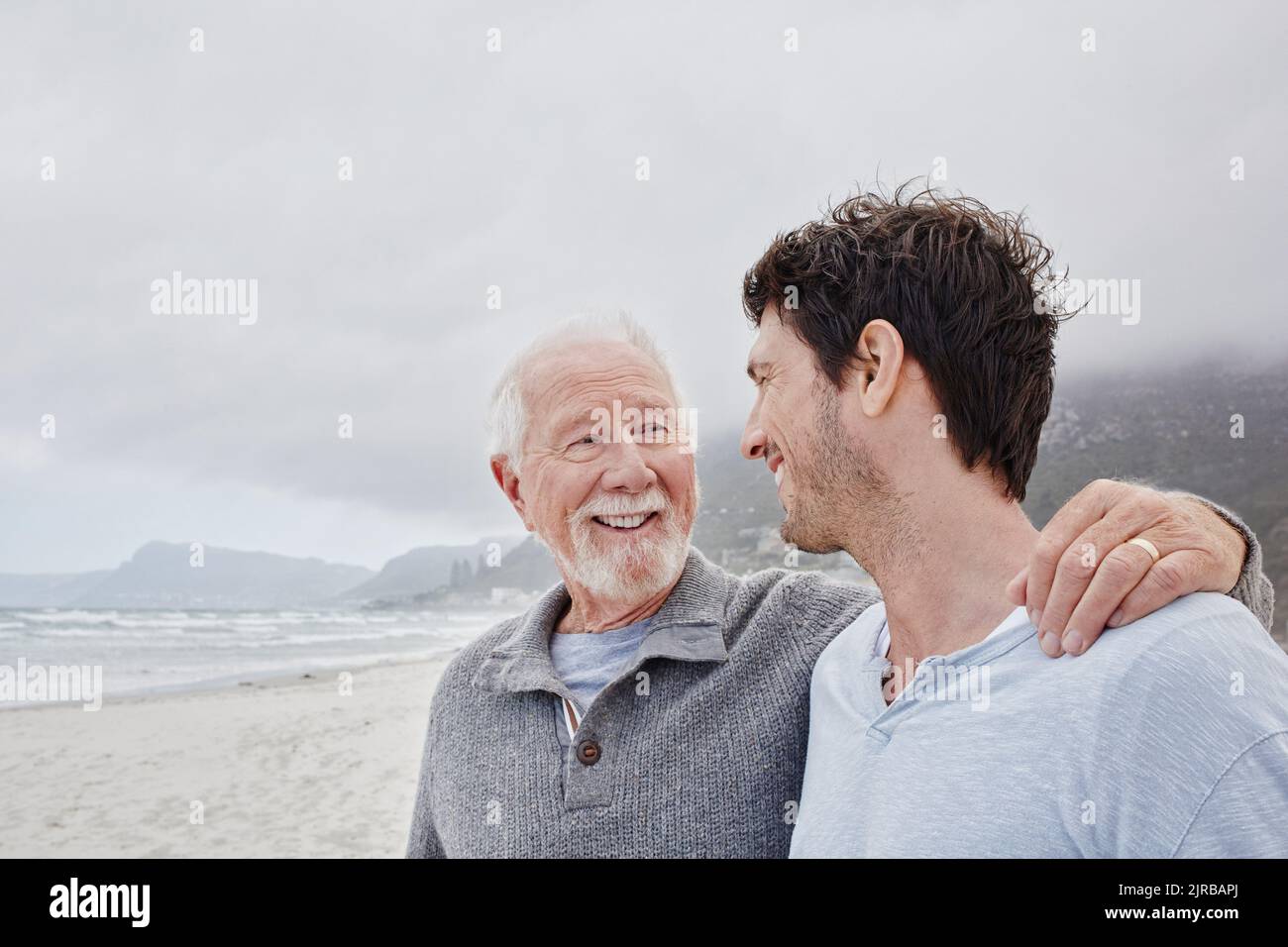 Proud father standing on the beach with his adult son Stock Photo - Alamy