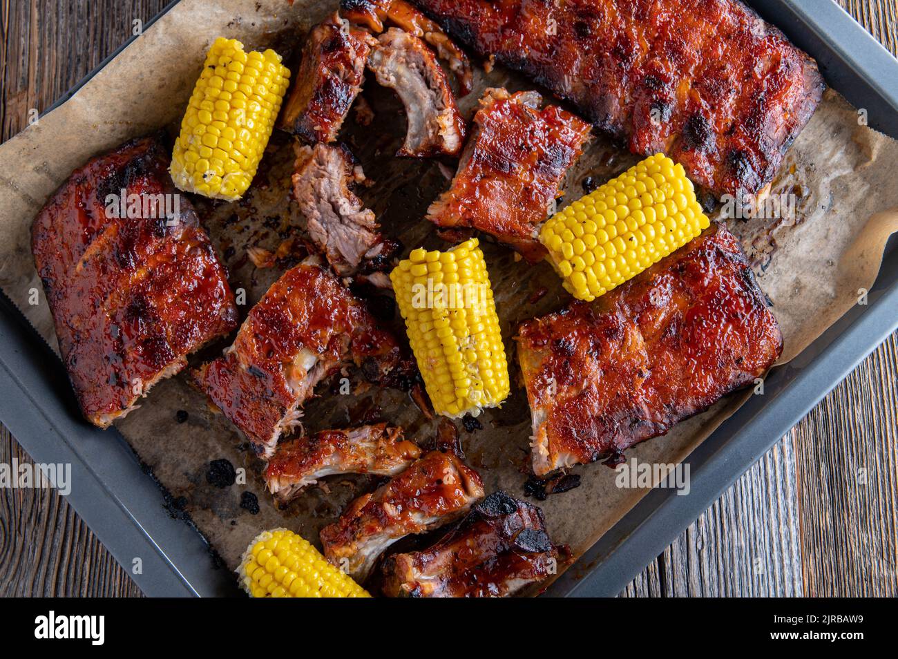 Marinated pork ribs with corn on the cop on a baking tray Stock Photo ...