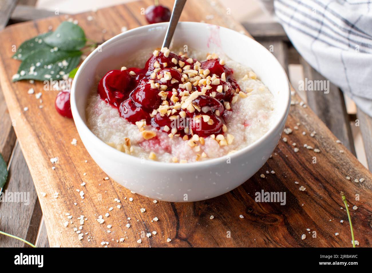 Millet breakfast porridge with cherry compote and roasted nuts Stock ...