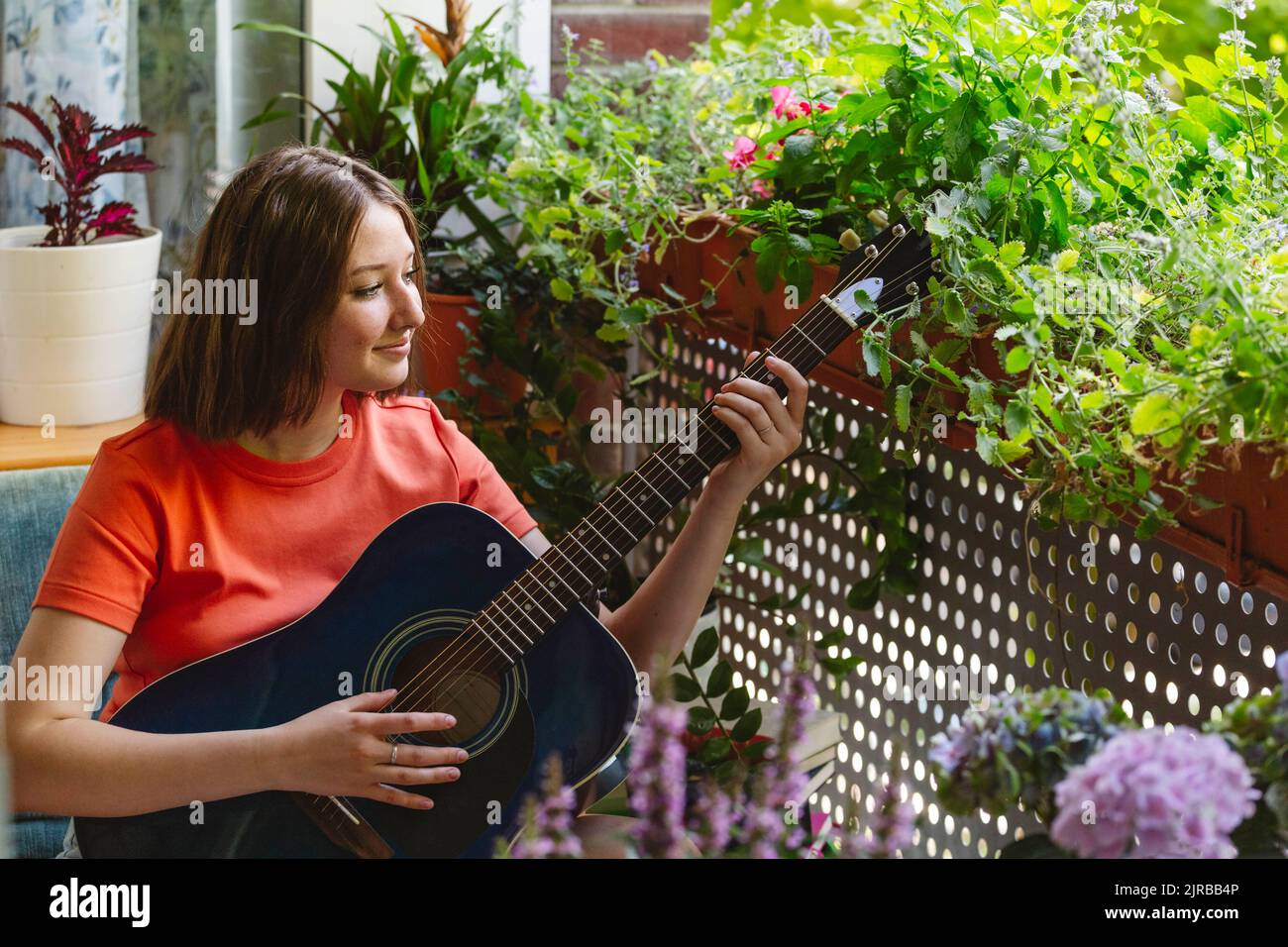 Teenage girl playing guitar on balcony Stock Photo - Alamy