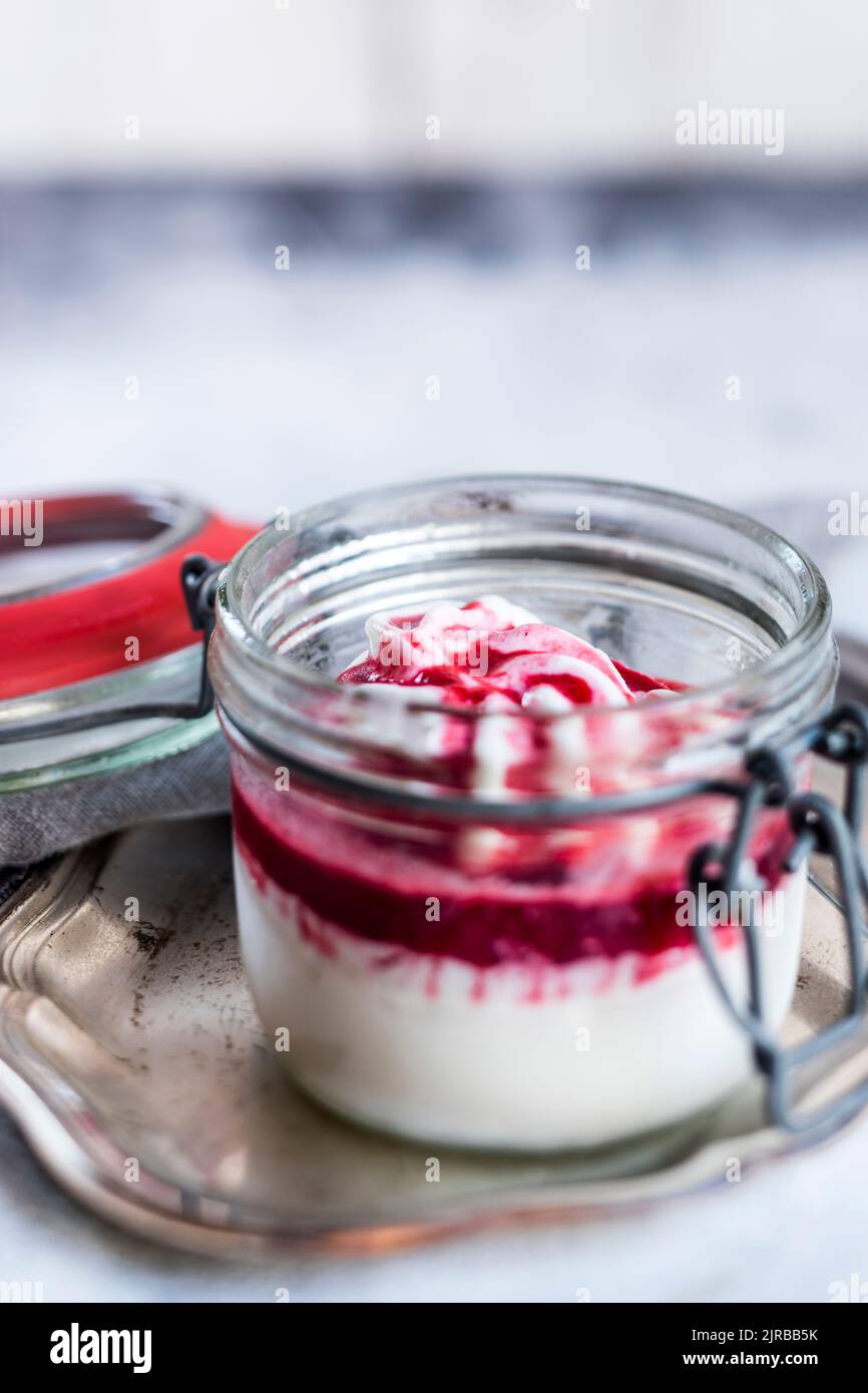 Jar of homemade frozen yogurt with raspberry topping Stock Photo - Alamy