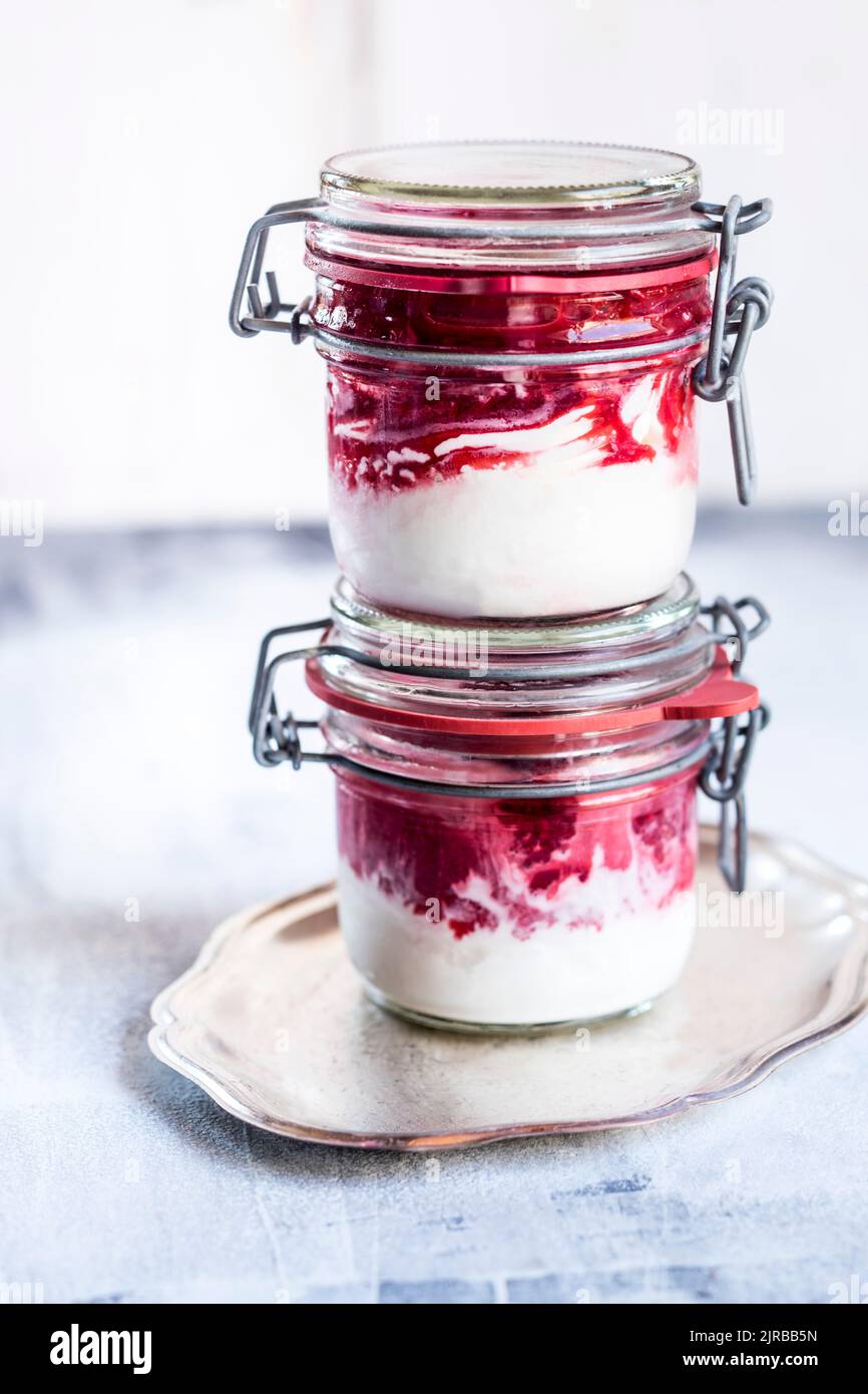 Two jars of homemade frozen yogurt with raspberry topping Stock Photo ...
