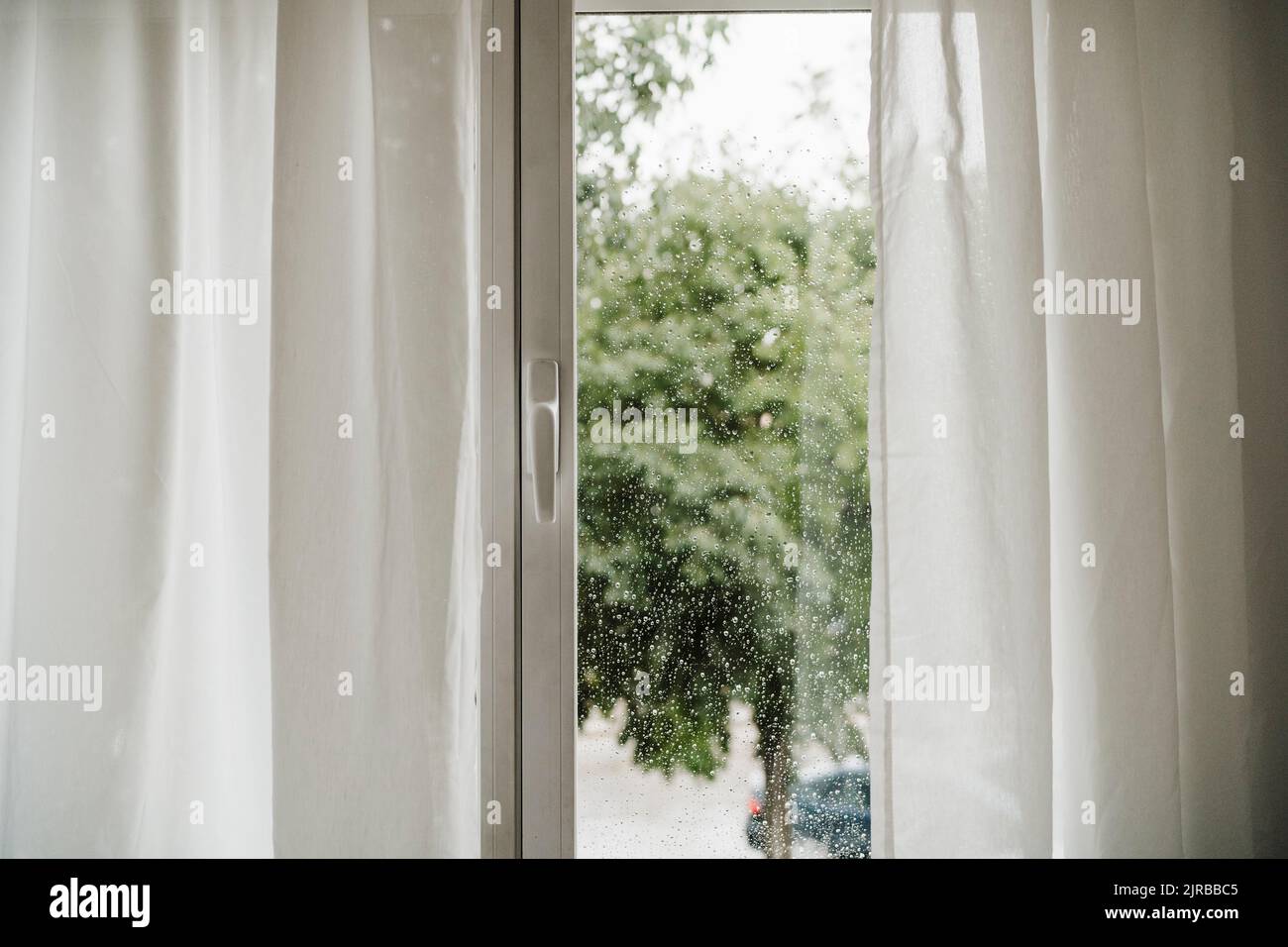 Raindrops on window seen through glass Stock Photo - Alamy