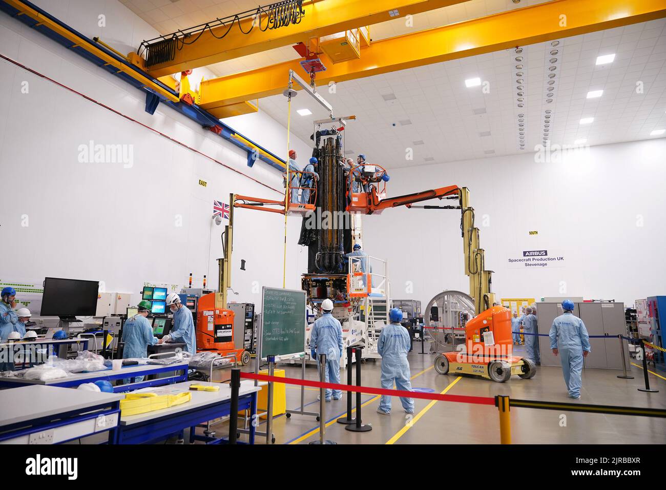 Members of staff work on the Biomass satellite at the Airbus factory in ...