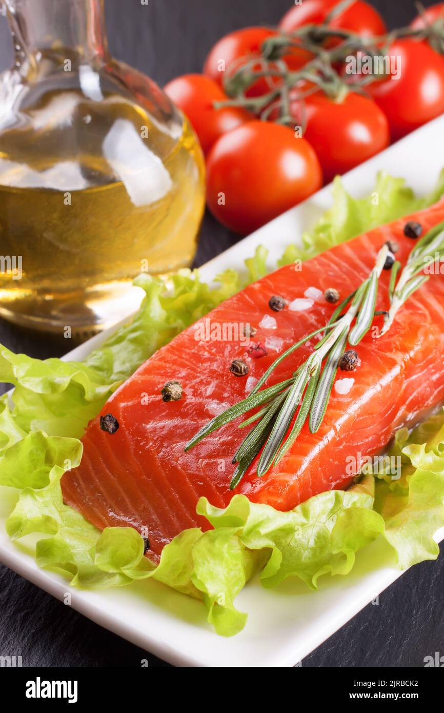 Raw salmon fillet, spices and vegetables on a white plate Stock Photo ...